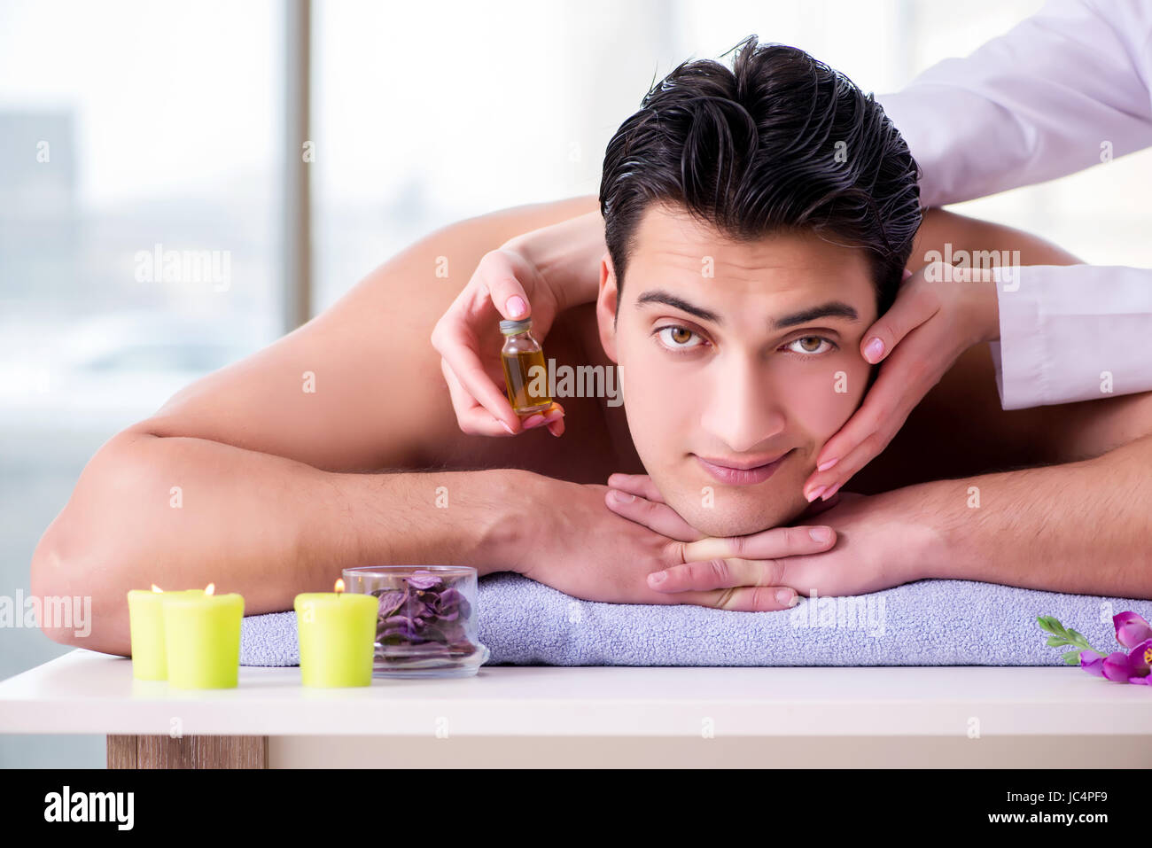 Handsome man in spa massage concept Stock Photo - Alamy