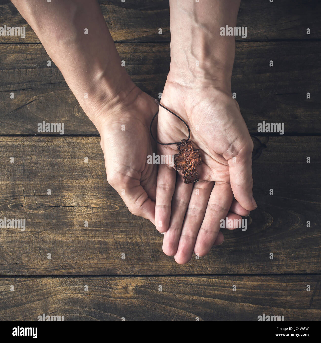 Hands on the cross hi-res stock photography and images - Alamy