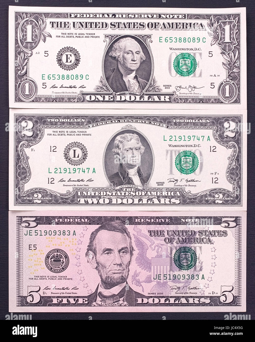 Pile of dollar bills of different denominations on black background ...