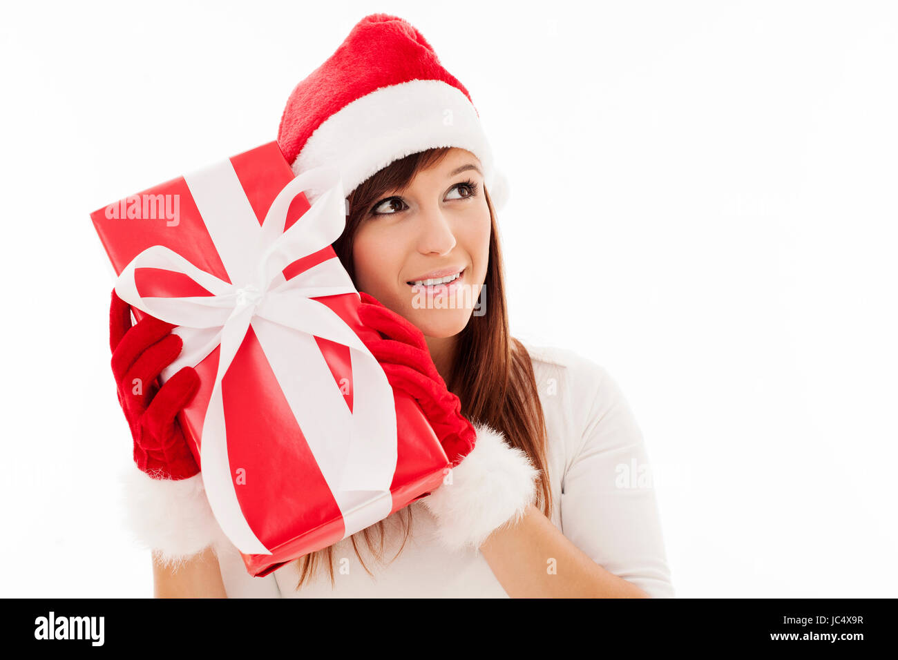 Beautiful woman shaking christmas present Stock Photo - Alamy