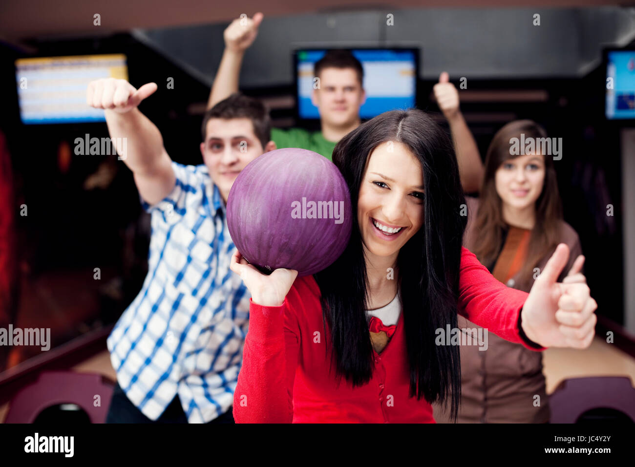 Friends bowling together Stock Photo - Alamy