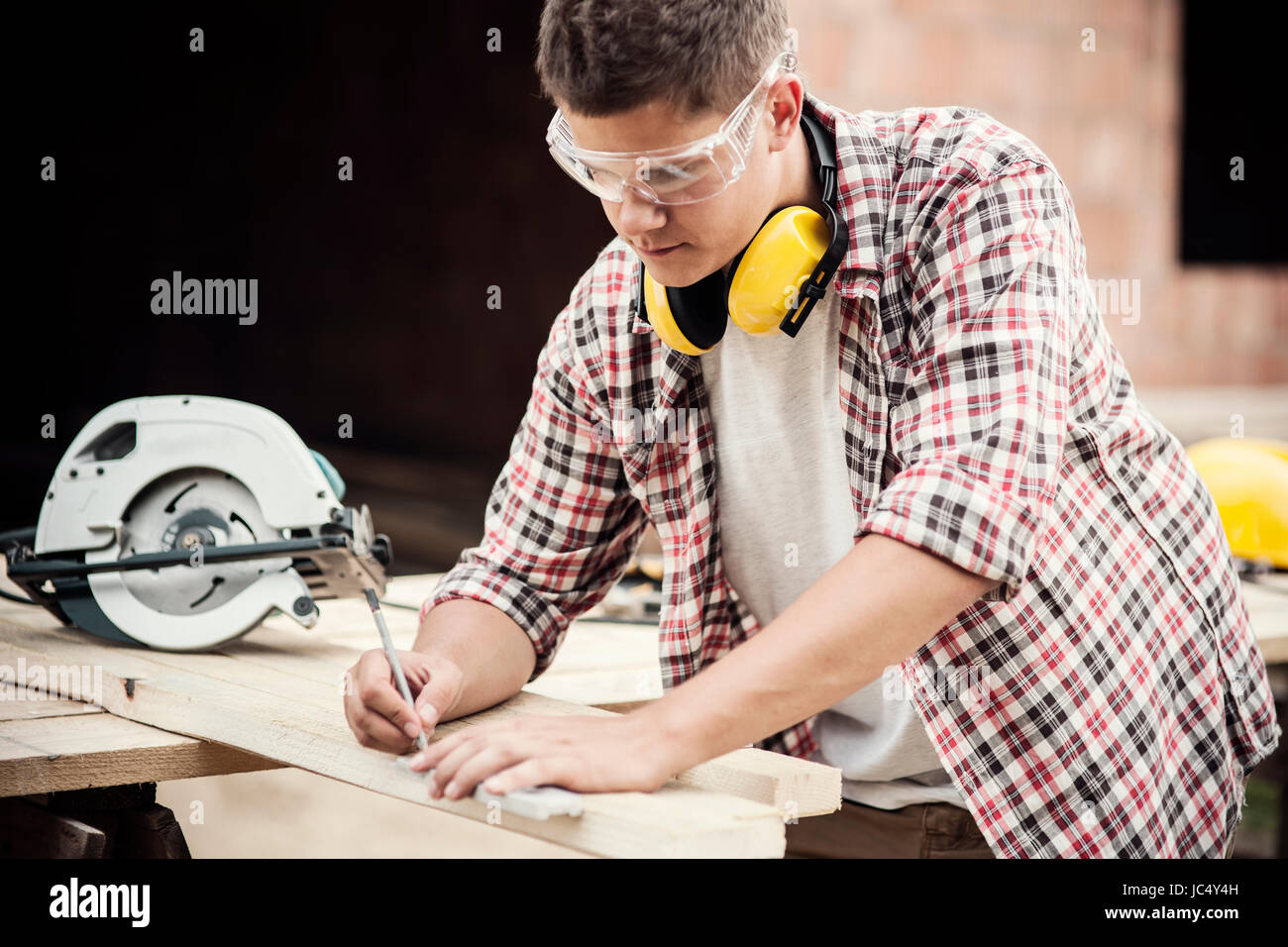 Carpenter measuring a wooden plank Stock Photo - Alamy