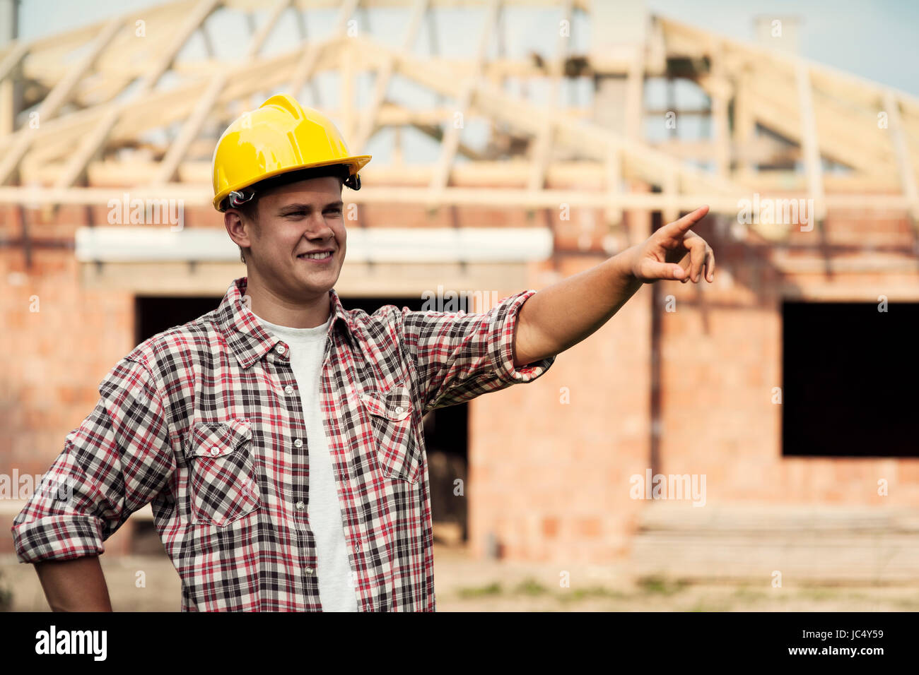 Construction worker pointing at something Stock Photo - Alamy