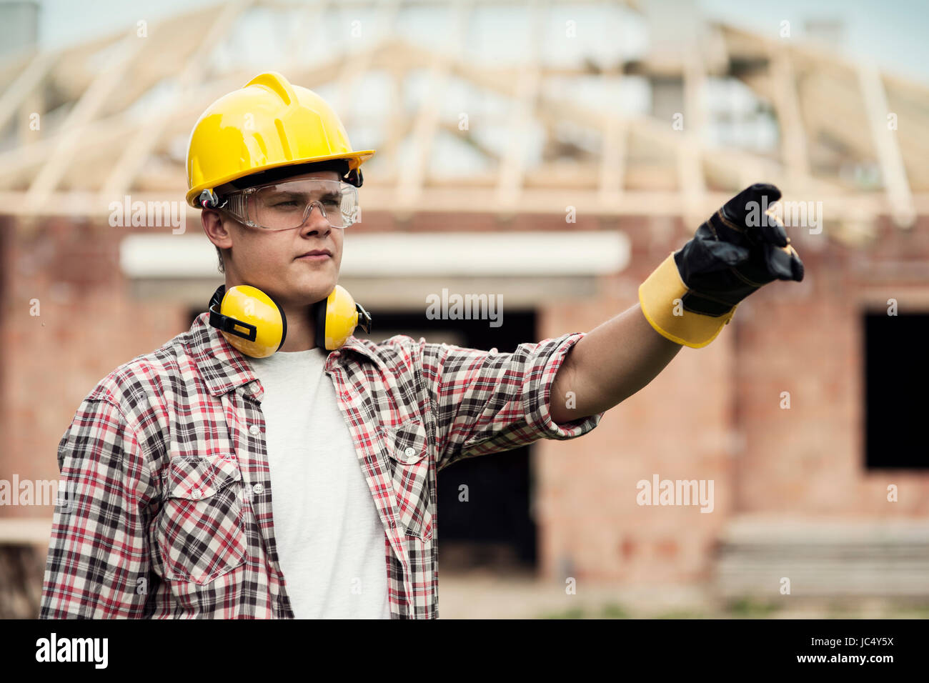 Construction worker pointing at something Stock Photo - Alamy
