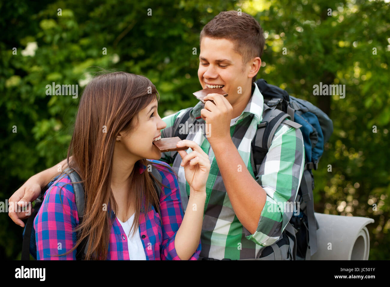 Young couple eating chocolate in forest Stock Photo - Alamy