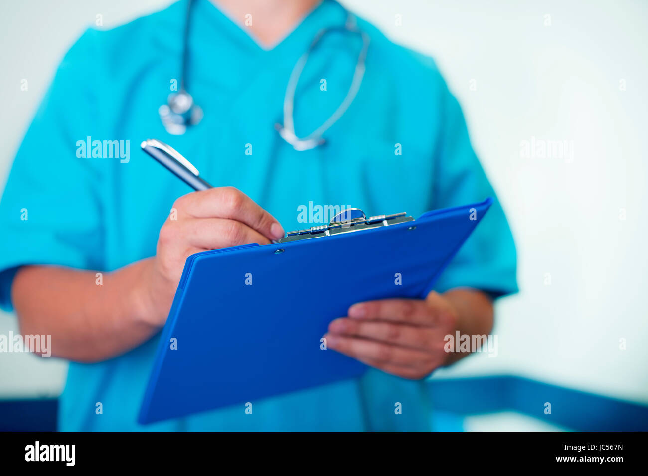 Doctor writing down on medical chart Stock Photo - Alamy