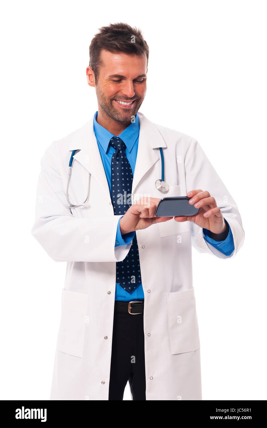 Handsome doctor text messaging Stock Photo - Alamy