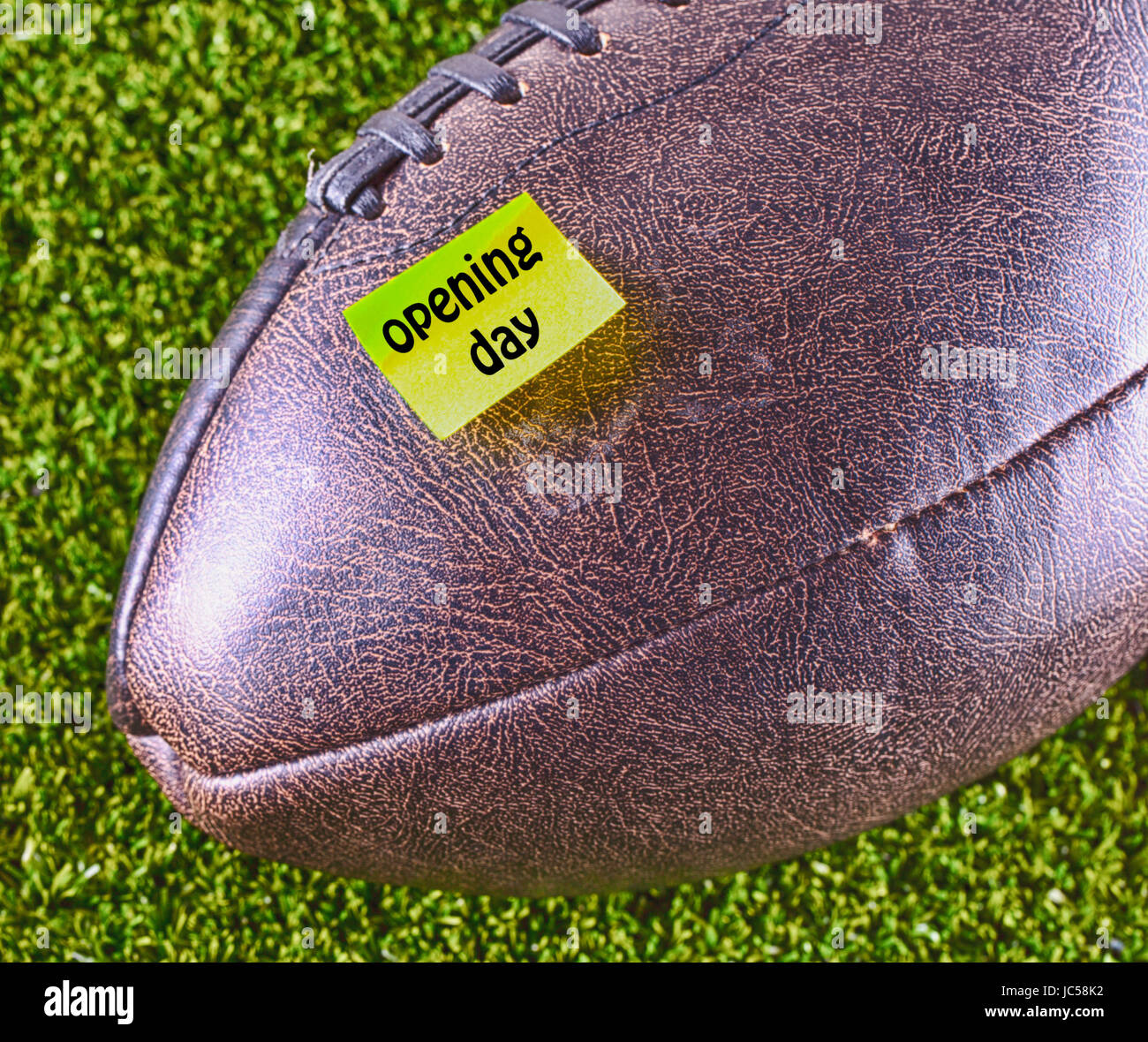 Football with yellow note telling "Opening day", over grass Stock Photo ...