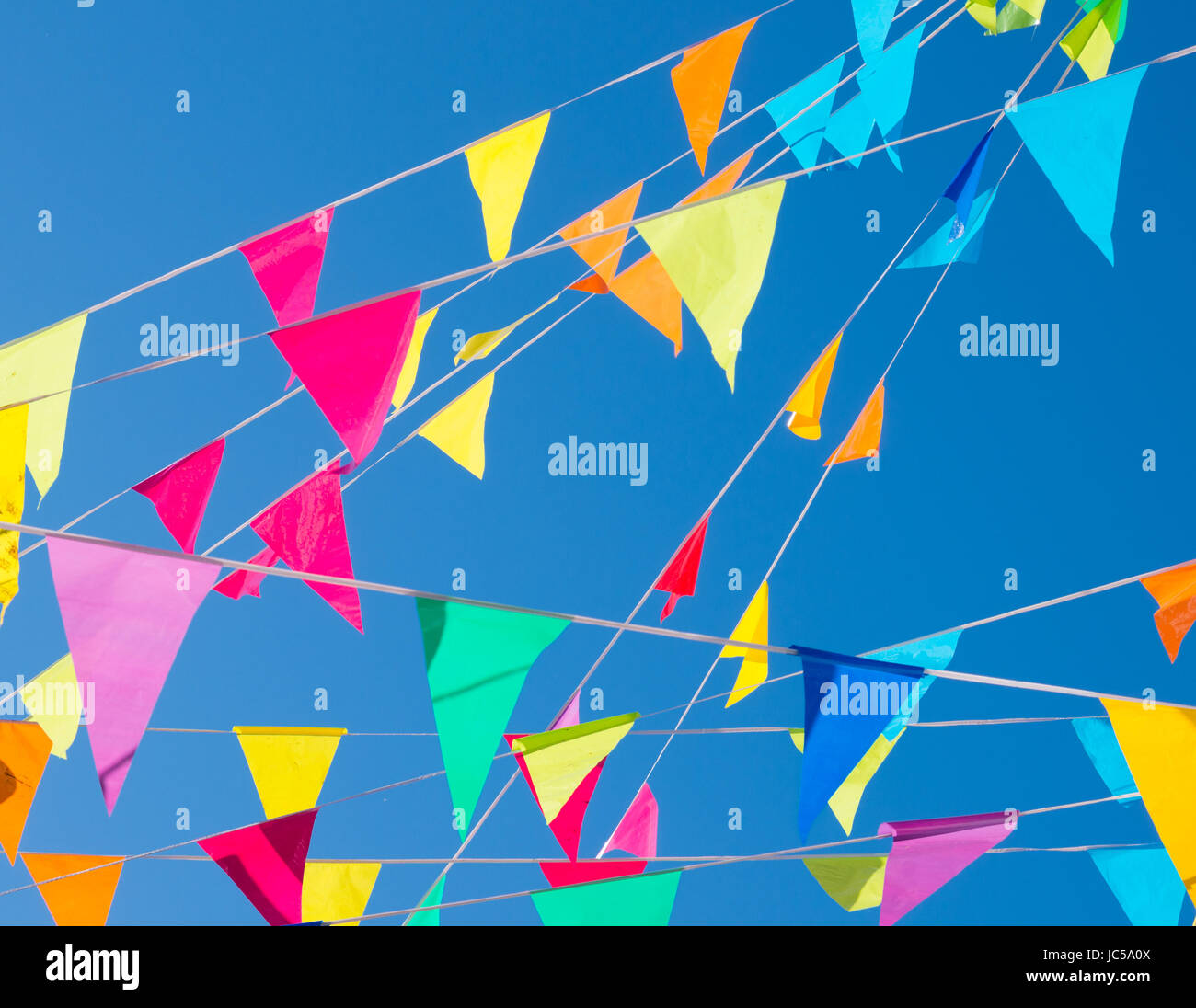 colorful bunting flags against a blue sky Stock Photo - Alamy