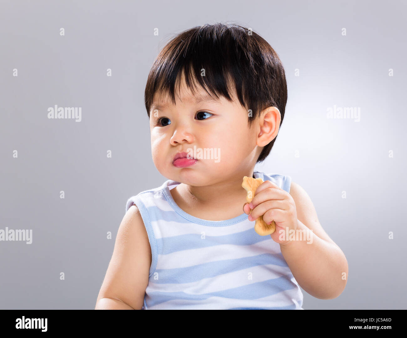 Baby boy eat biscuit Stock Photo - Alamy