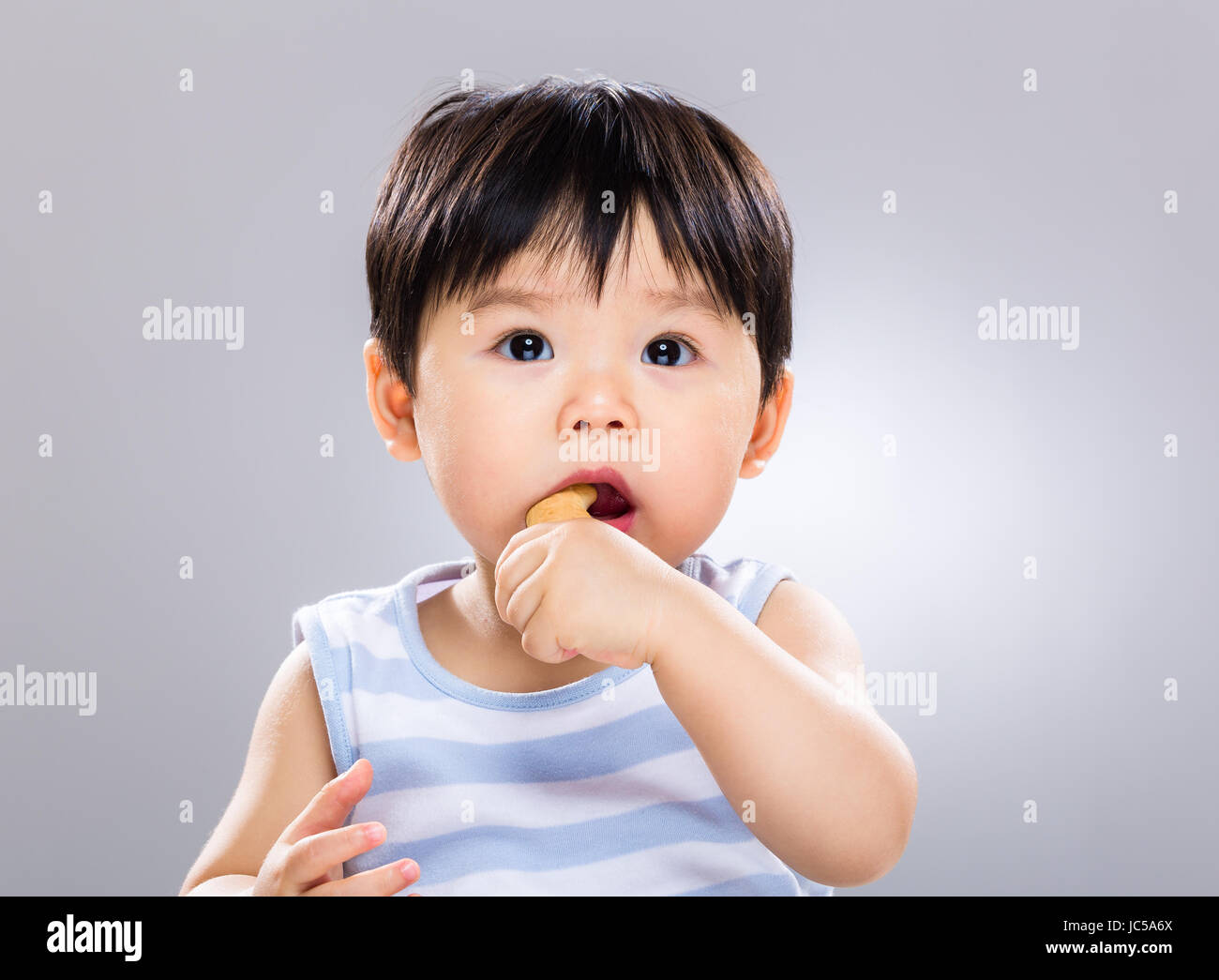 Baby boy eat biscuit Stock Photo - Alamy