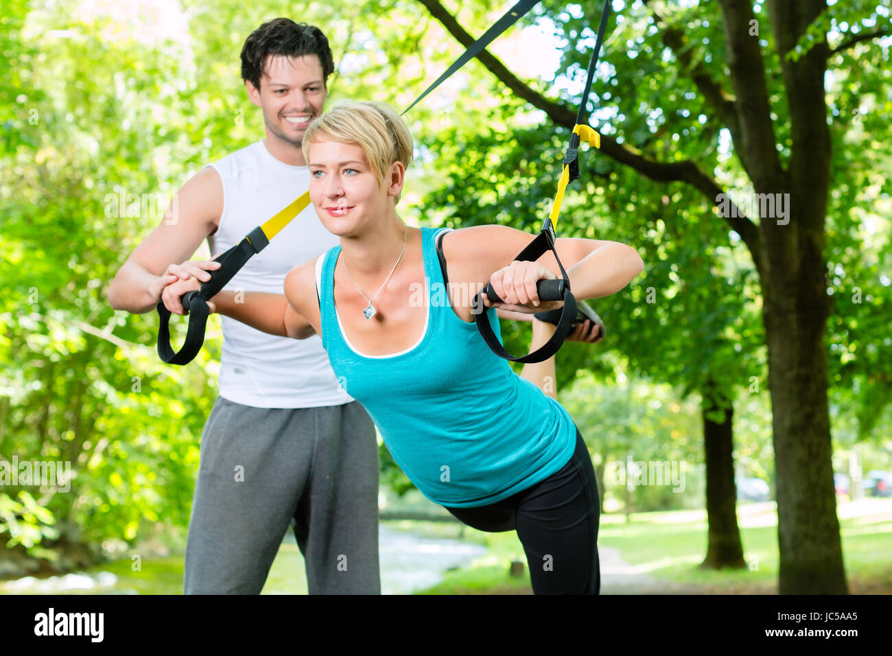 Fitness woman exercising with suspension trainer and personal sport ...