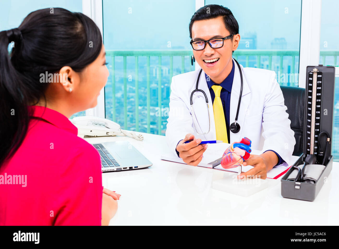 Asian doctor giving patient medical advice in practice or office Stock ...