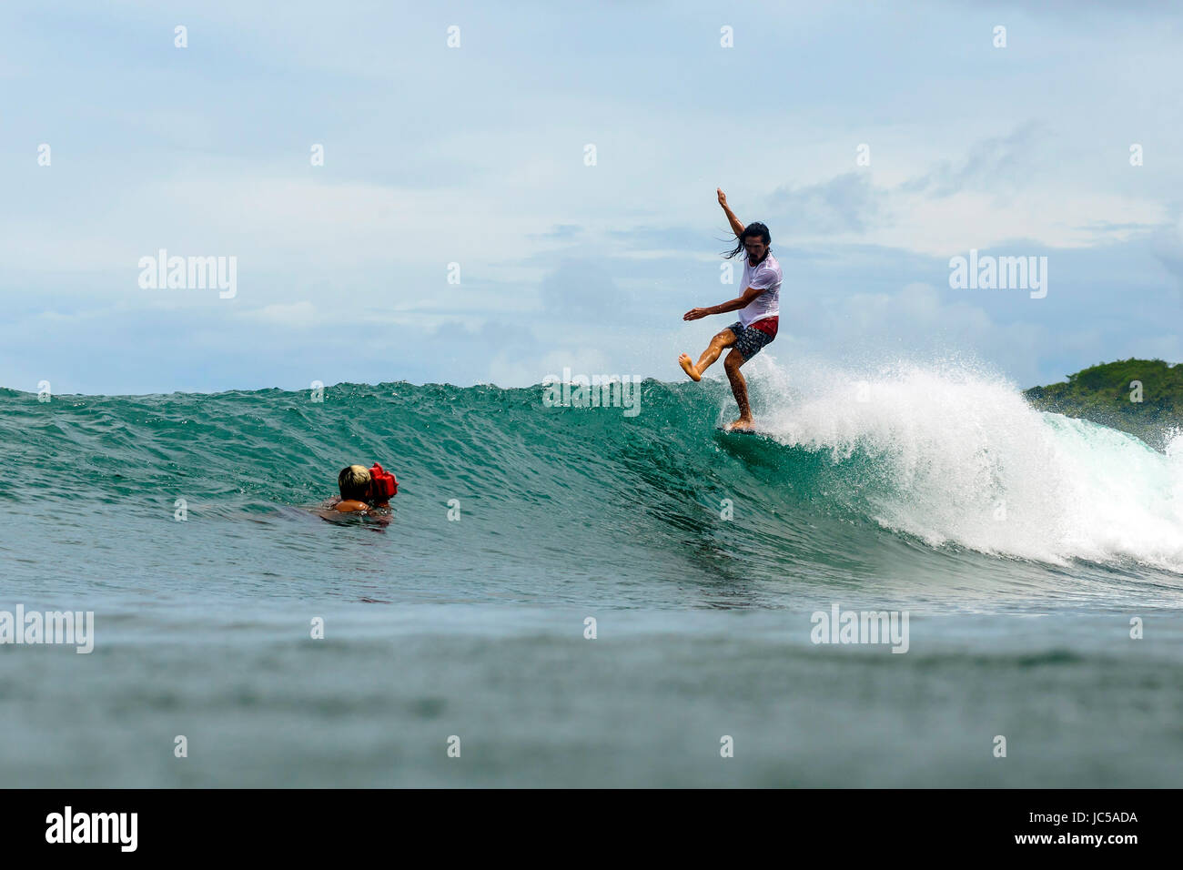 Photographer photographing male surfer Stock Photo - Alamy