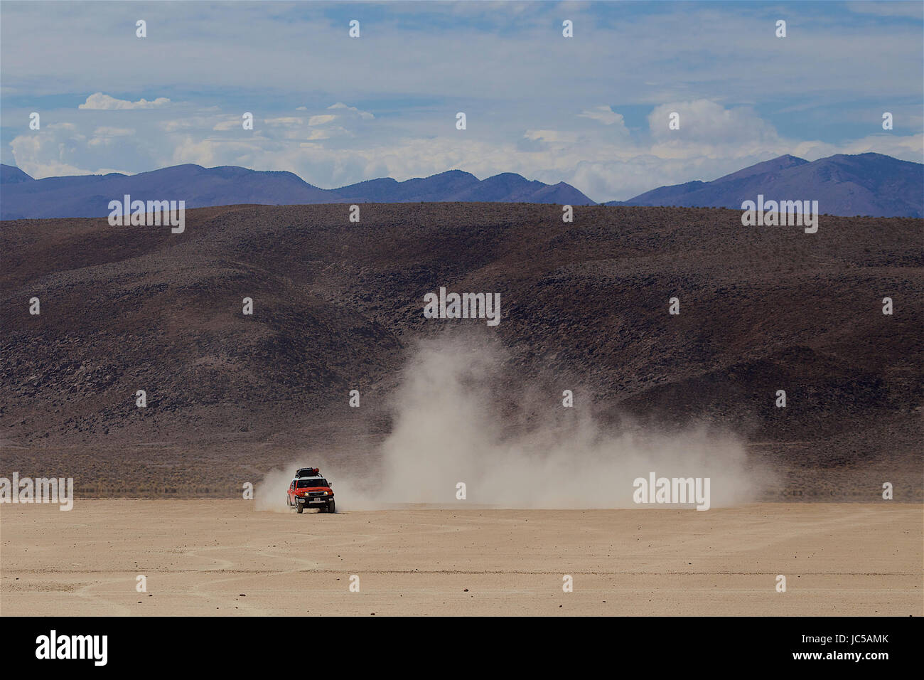 Car leaving dust track in desert Stock Photo - Alamy