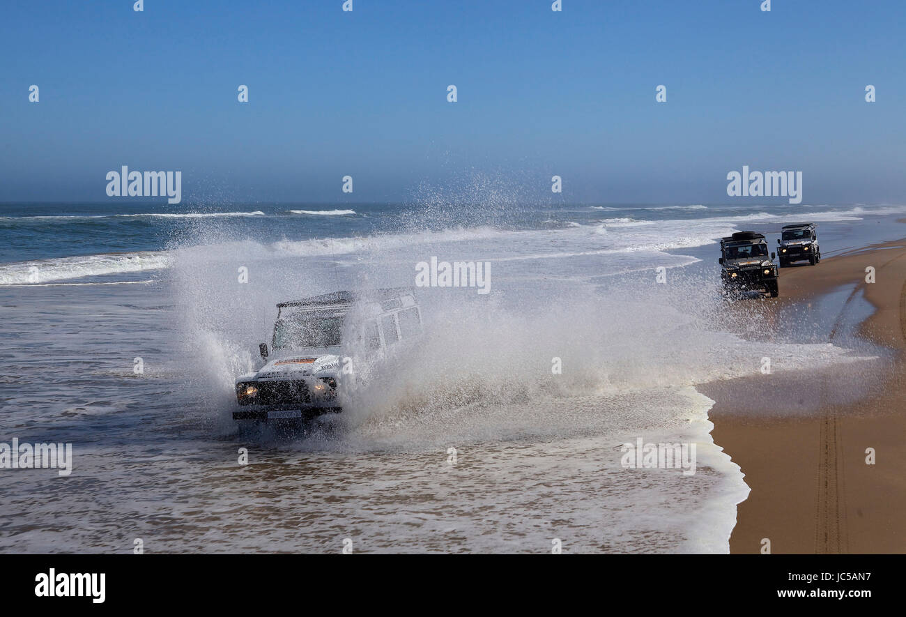 Cars splash through the surf while racing on beach Stock Photo - Alamy