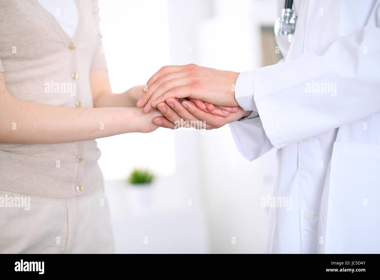 Hand of doctor reassuring her female patient Stock Photo - Alamy