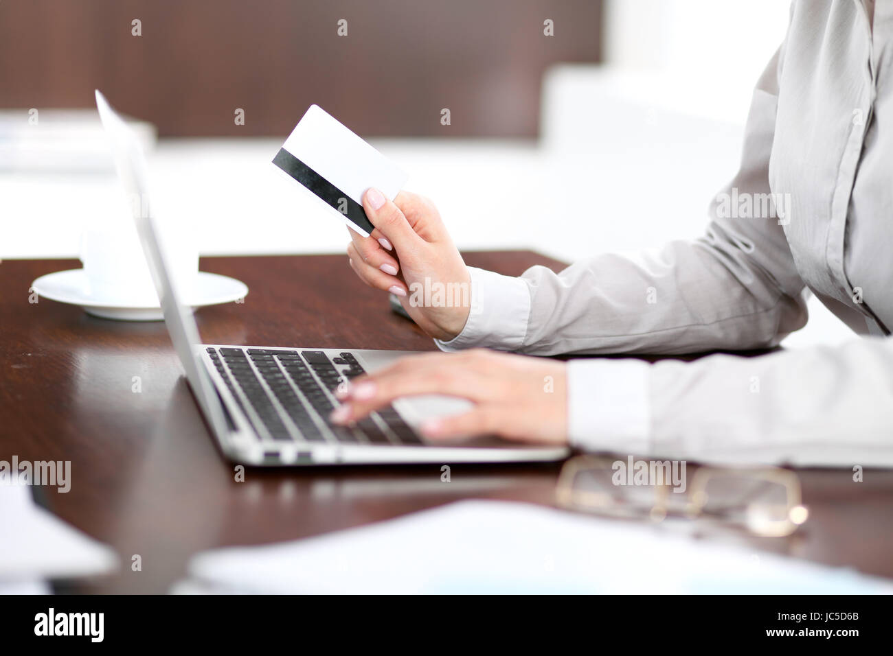 Close up of business woman hands using credit card and laptop computer ...