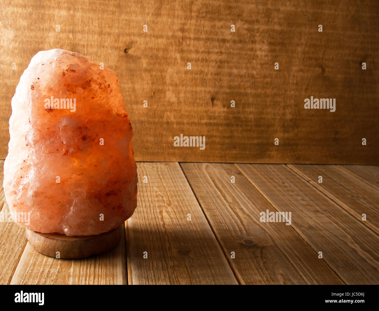 Himalayan salt lamp on wooden background Stock Photo - Alamy