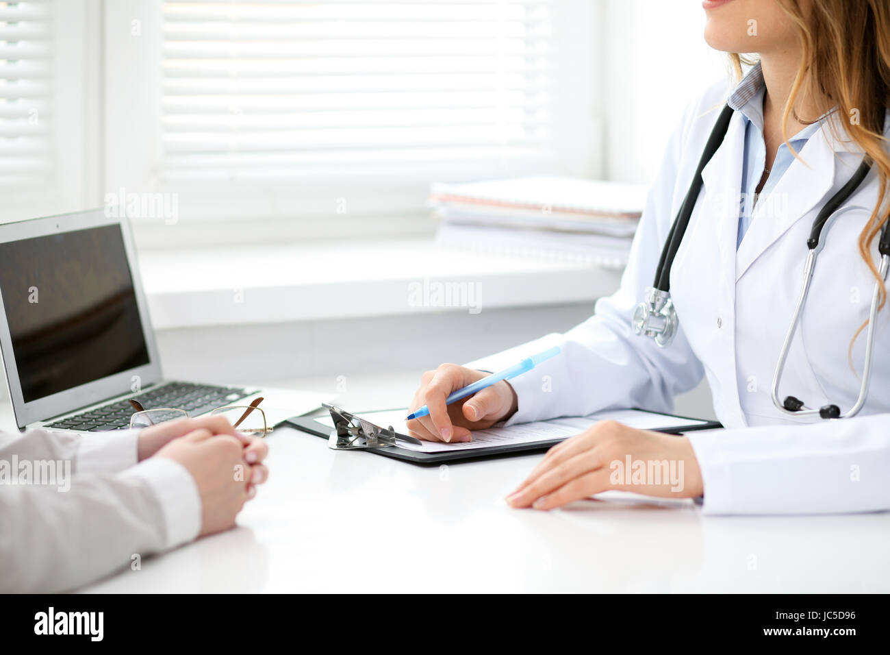 Doctor and patient sitting at the desk Stock Photo - Alamy