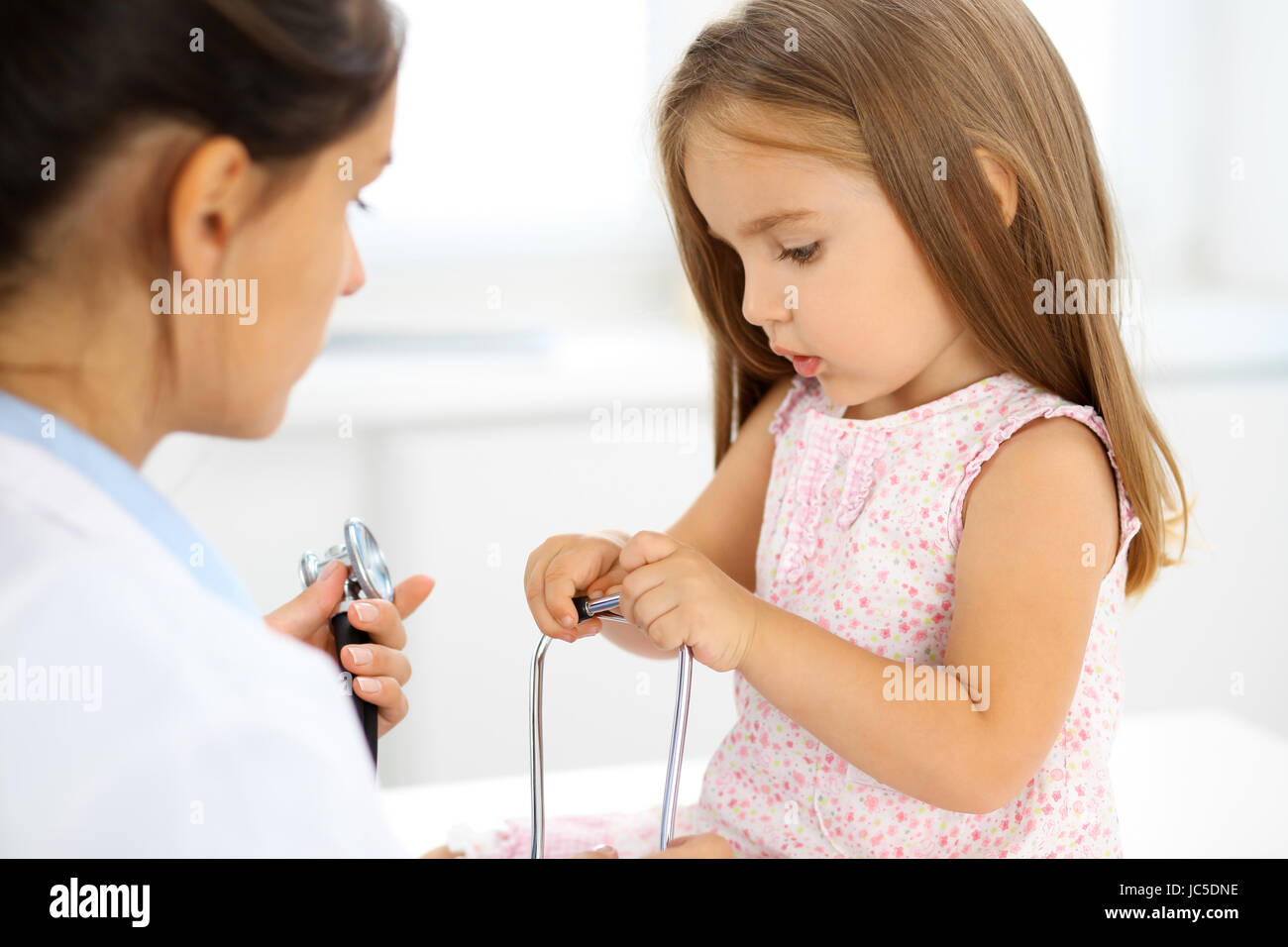 Happy little girl at health exam at doctor office. Medicine and health ...