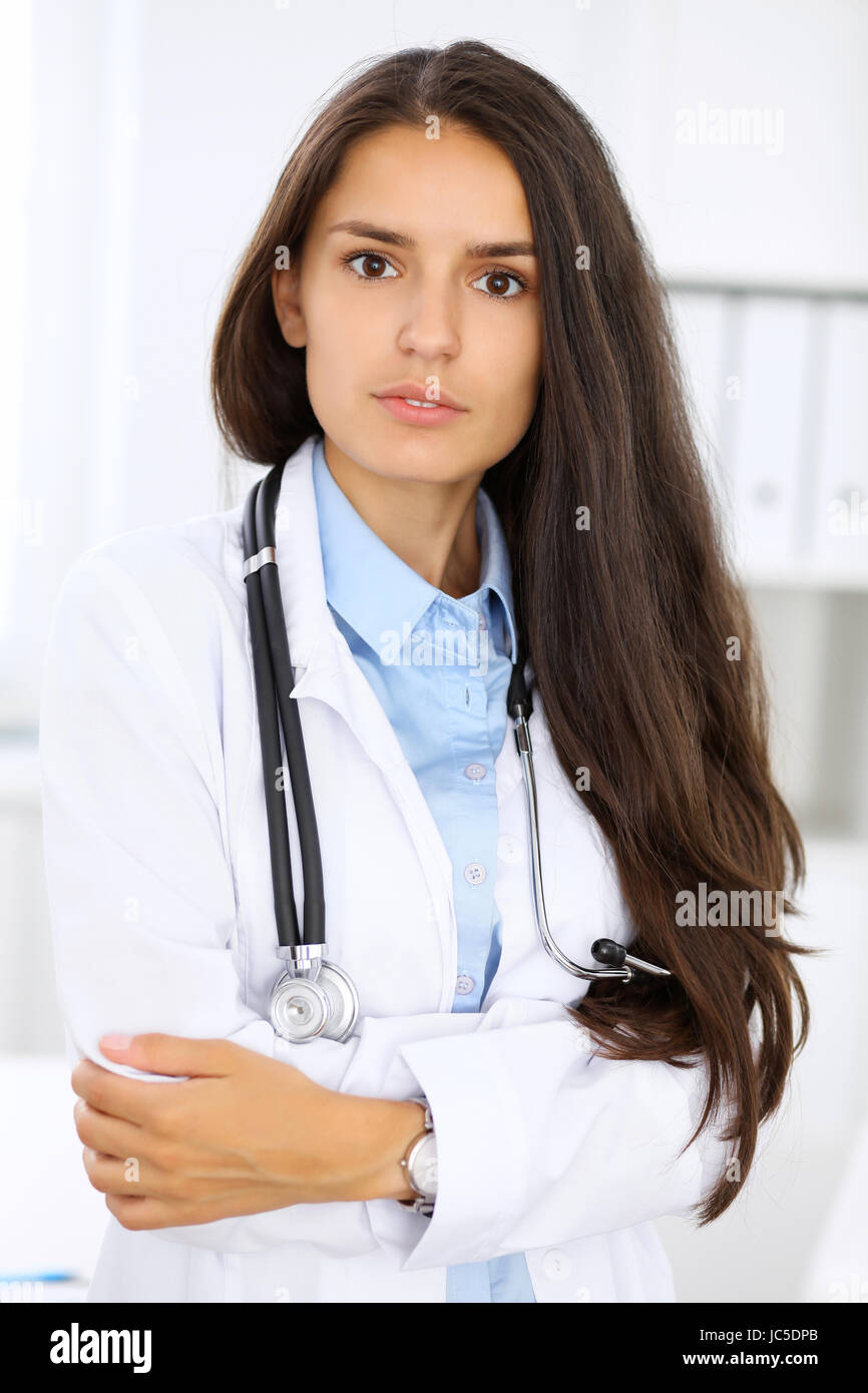 Beautiful young smiling female doctor standing at hospital Stock Photo ...