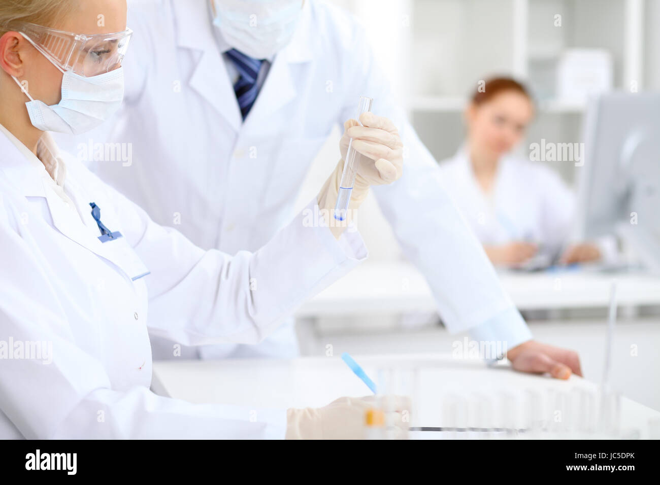 Scientific research team with clear solution in laboratory Stock Photo ...