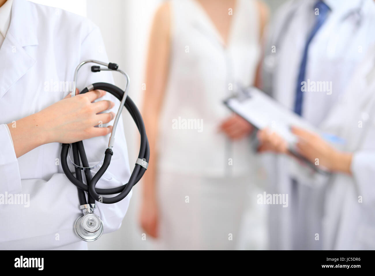 Female doctor holding a stethoscope in his hand, two doctors and ...