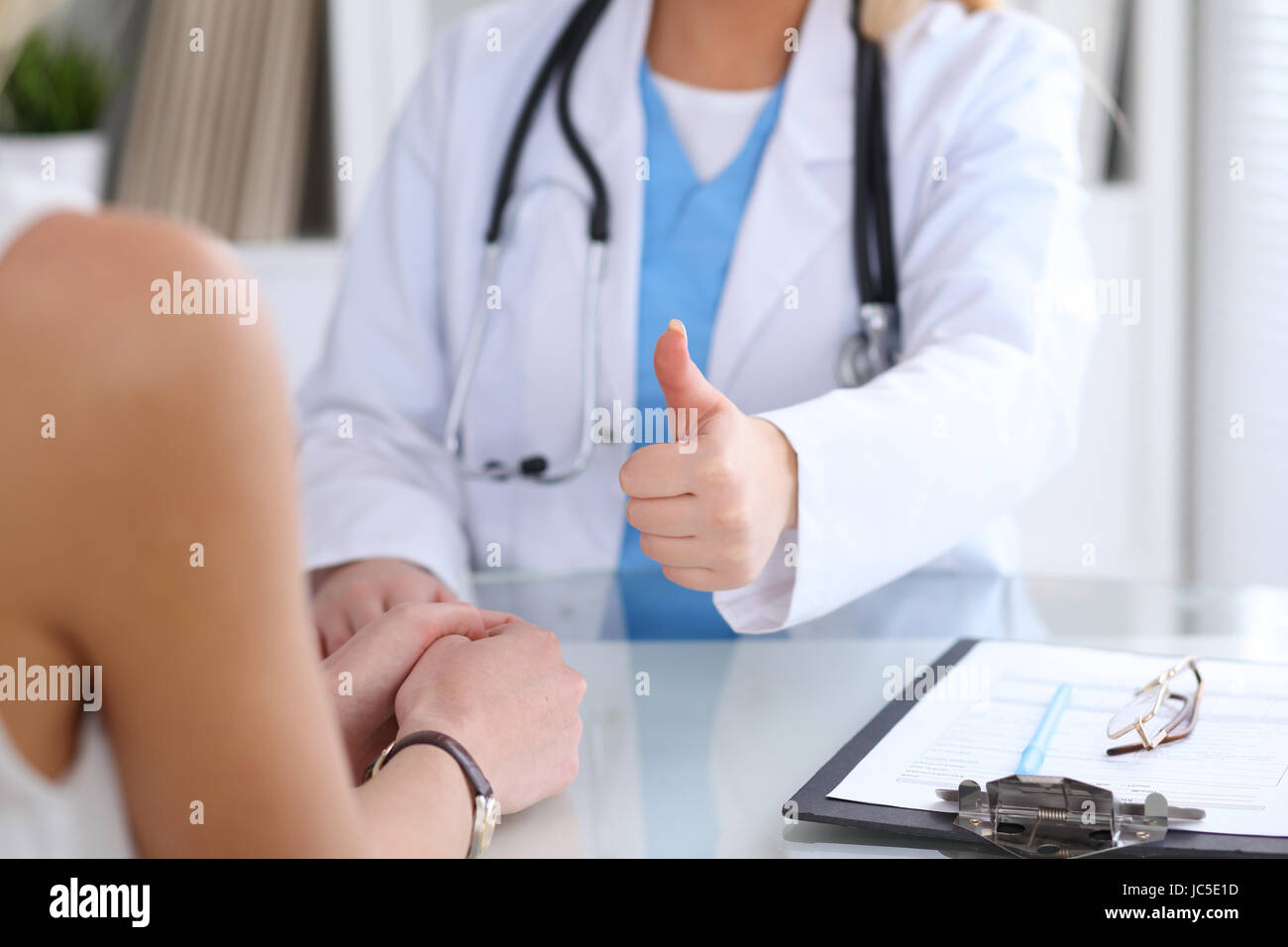 Close up of a doctor hands while showing thumbs up sign to her patient ...