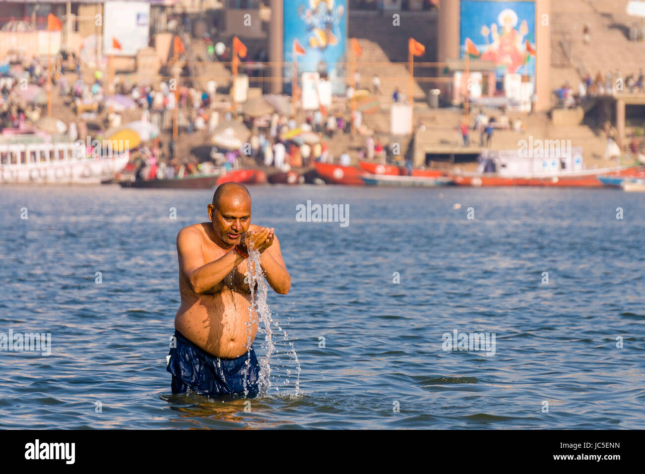 A man, pilgrim, is taking bath and praying on the sand banks at the ...