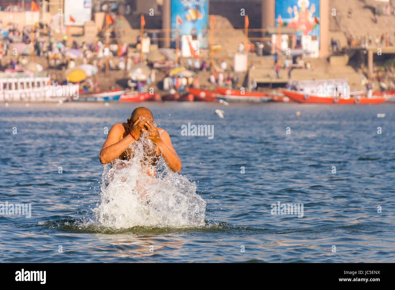 A man, pilgrim, is taking bath and praying on the sand banks at the ...