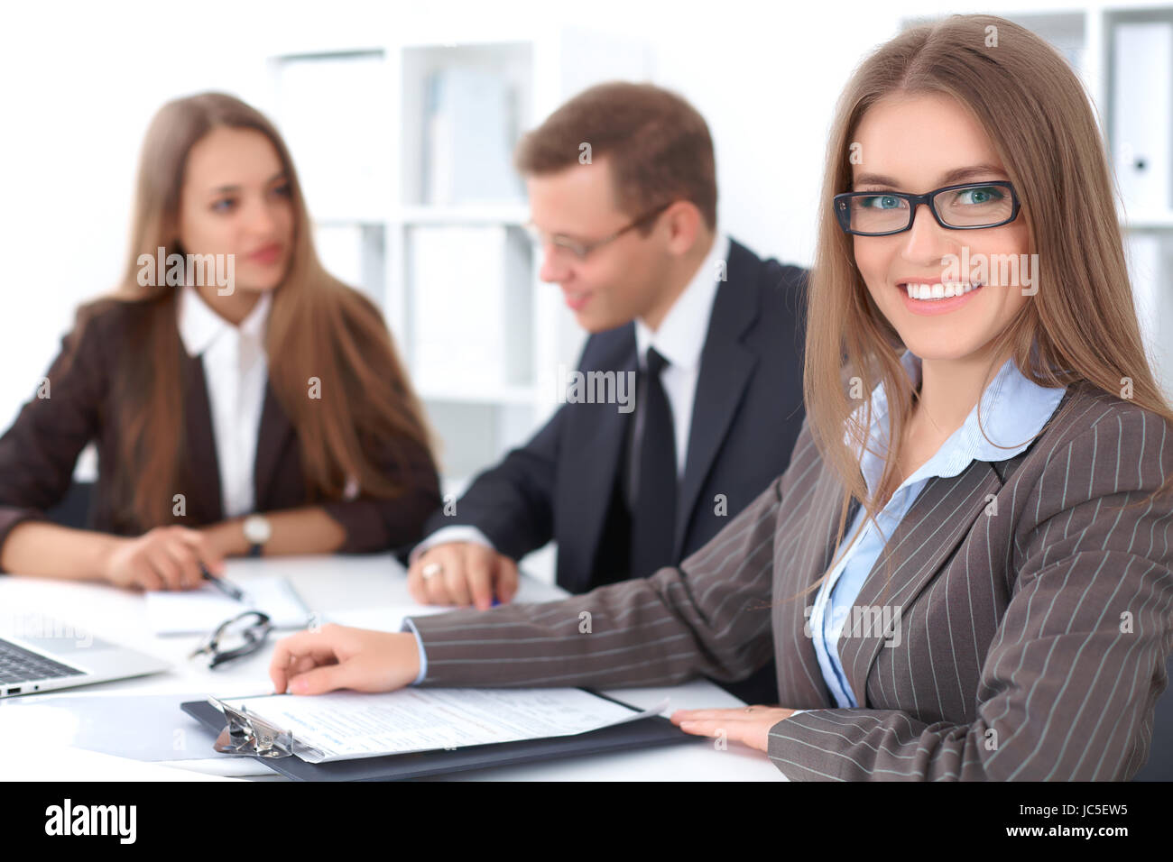 Group of business people at meeting. Focus on a beautiful brunette ...