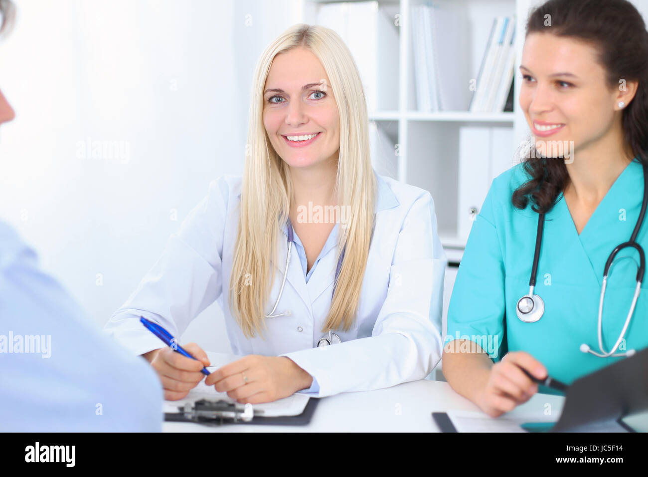 Patient listening doctors sitting table hi-res stock photography and ...