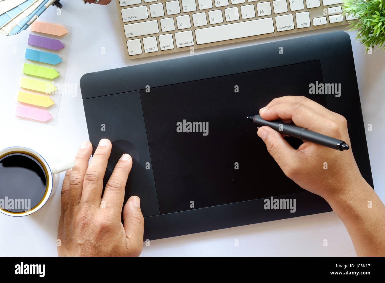 Graphic designer using graphics tablet to do his work at desk Stock ...