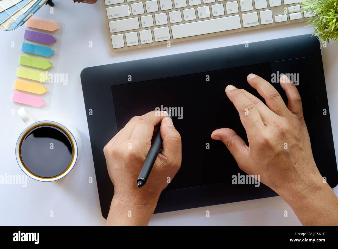 Graphic designer using graphics tablet to do his work at desk Stock ...