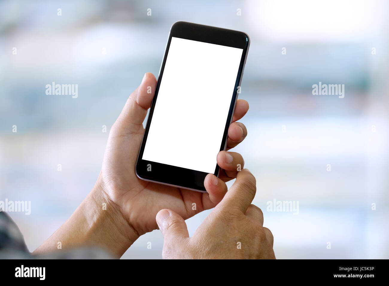 Man holding and using smartphone in office Stock Photo - Alamy