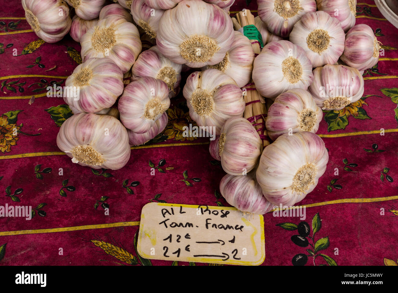 Garlic bunches (ail rose) displayed on a table at a outdoor market ...