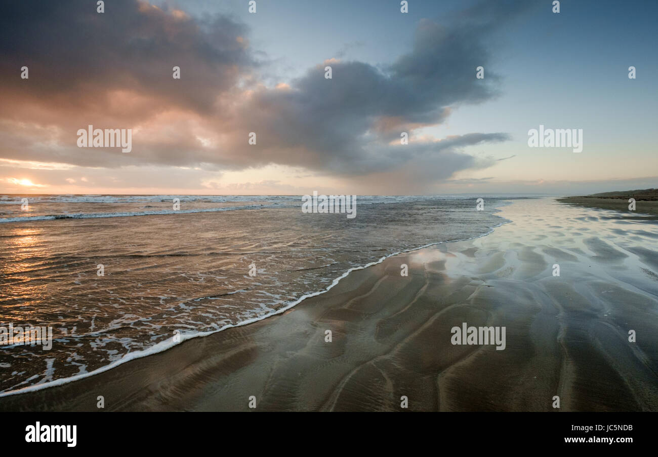 Waves flowing across the shallow sands of Pembrey Beach (Cefn Sidan ...