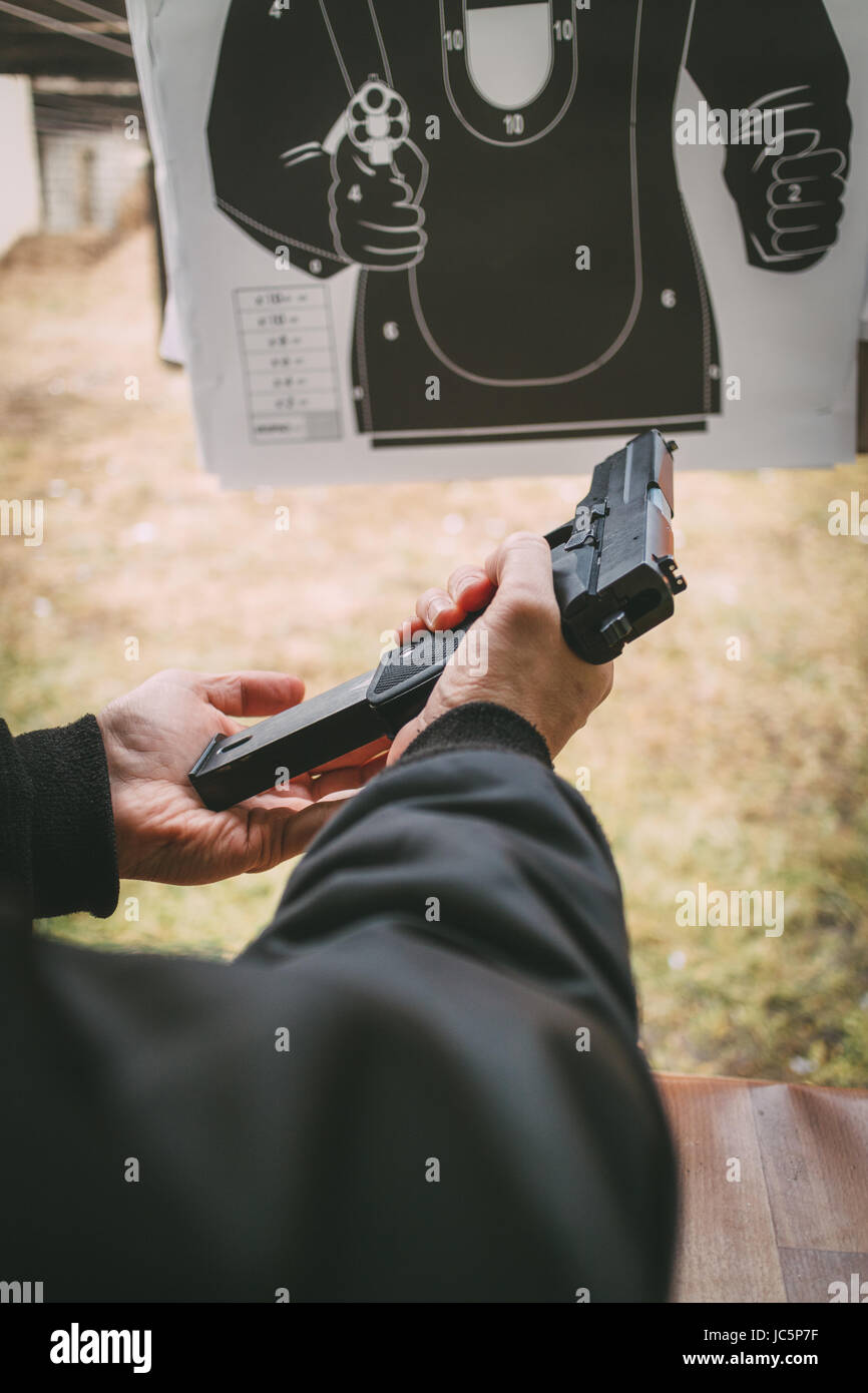 Close-up of a man hands holding and loading gun magazine in the pistol ...