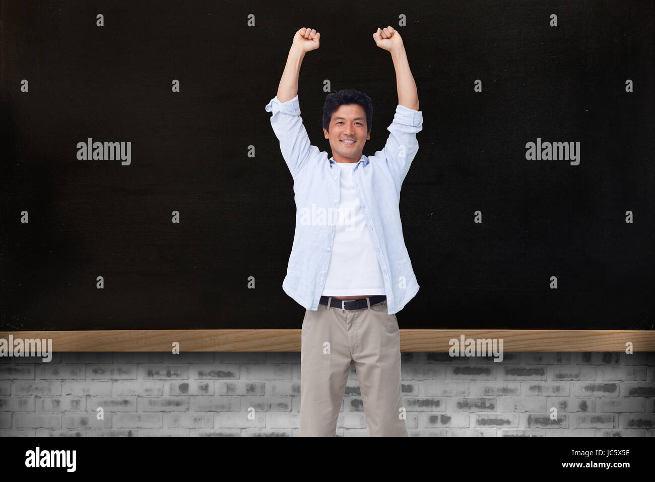 Composite image of cheering male with arms up Stock Photo - Alamy