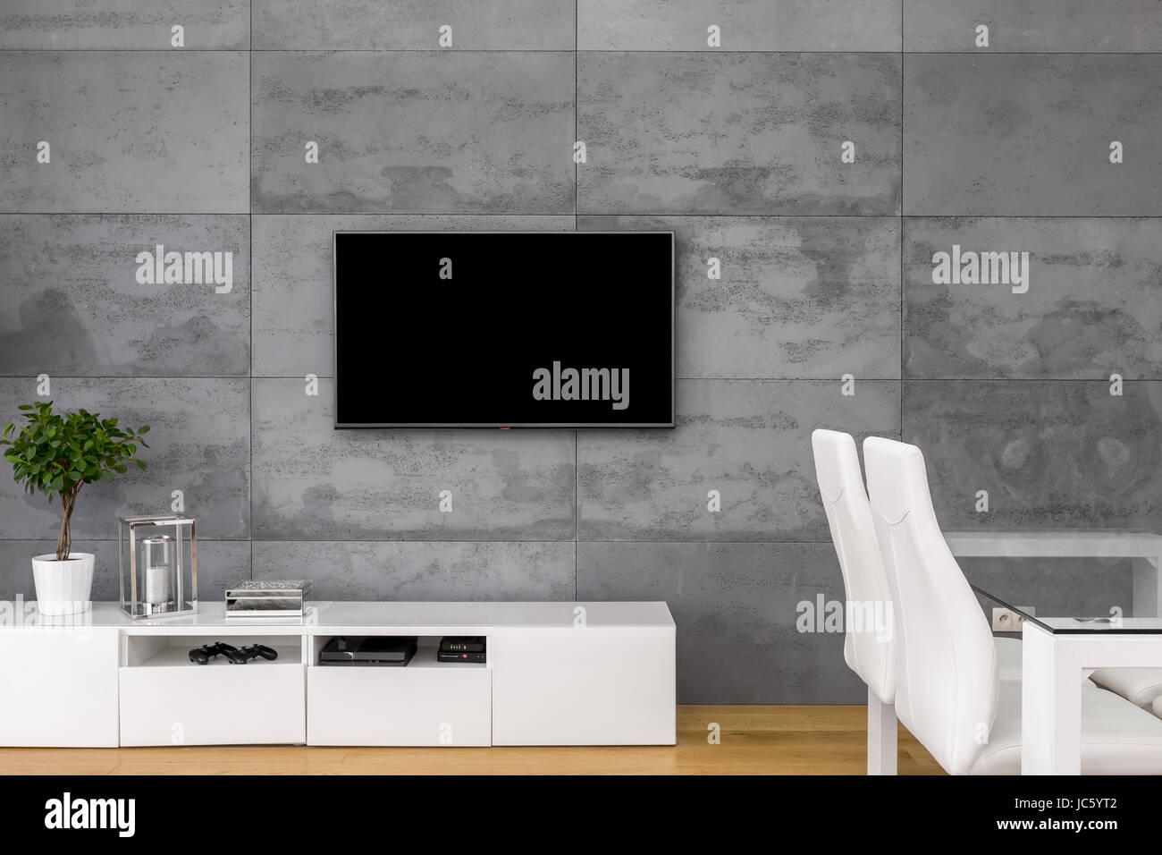 Tv living room with table, chairs and modern cabinet Stock Photo - Alamy