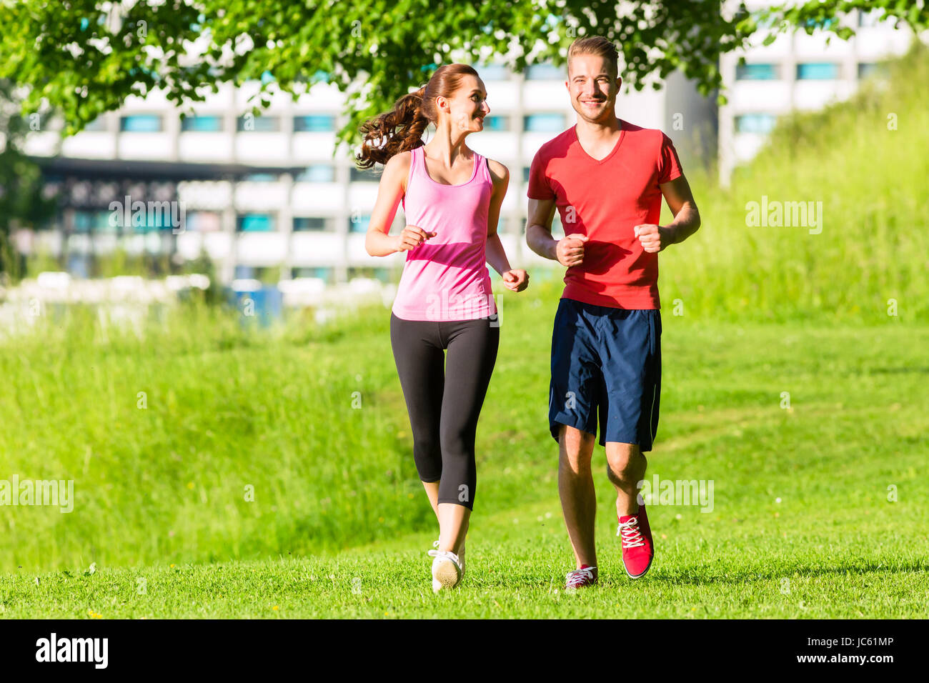 Fitness Friends running together through park Stock Photo - Alamy
