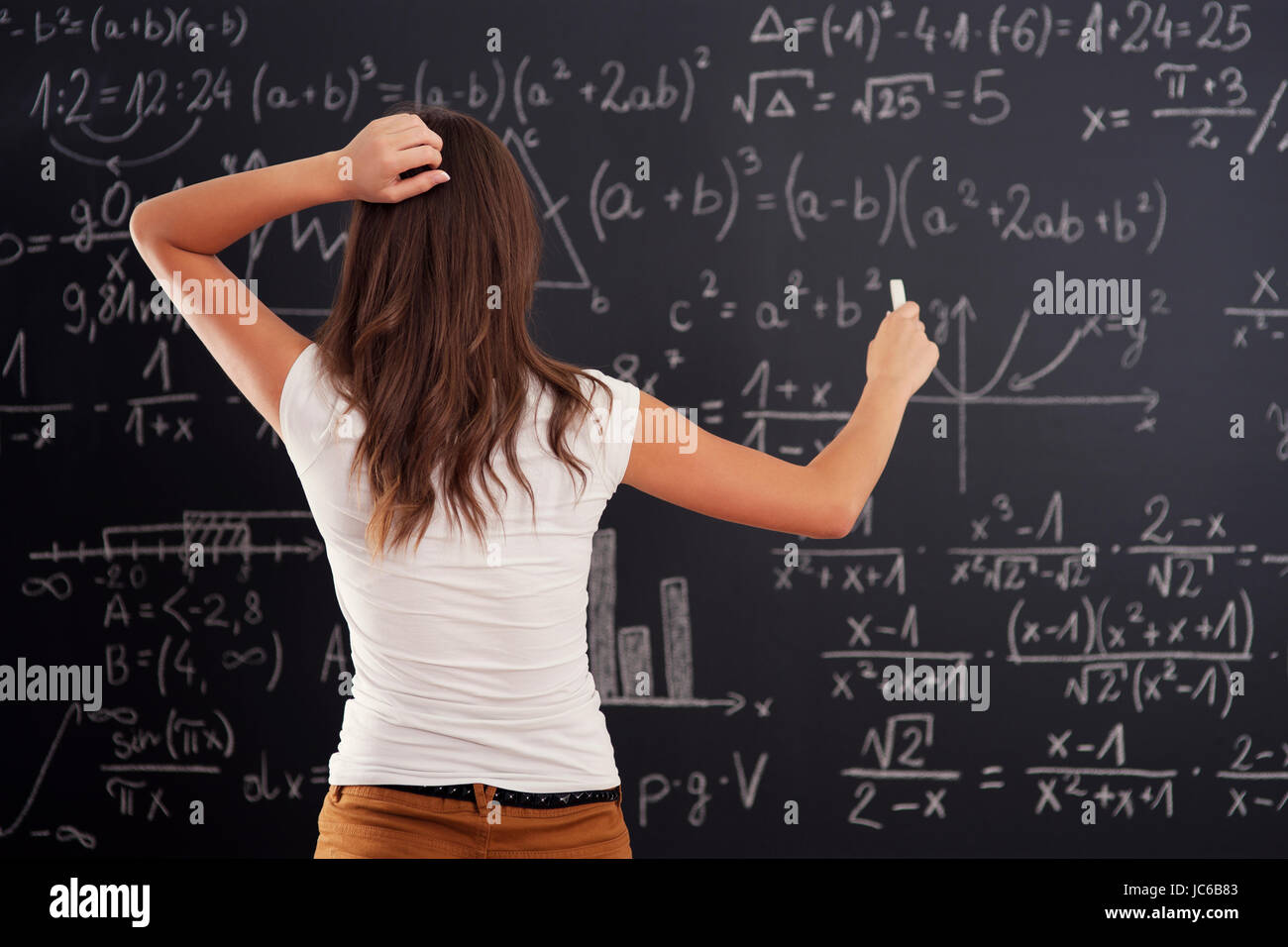 Young woman looking at math problem on blackboard Stock Photo - Alamy