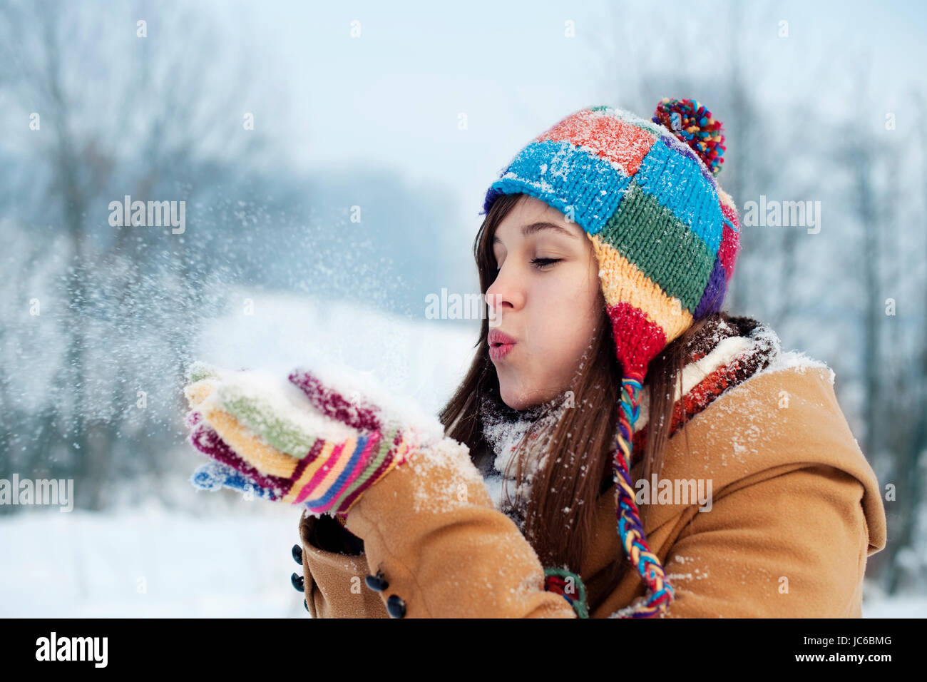 Young woman blowing snow to away Stock Photo - Alamy
