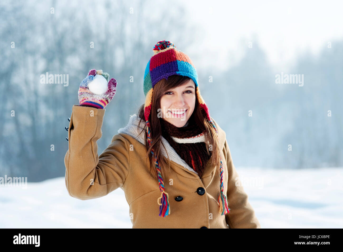 Young woman throwing snowball Stock Photo - Alamy