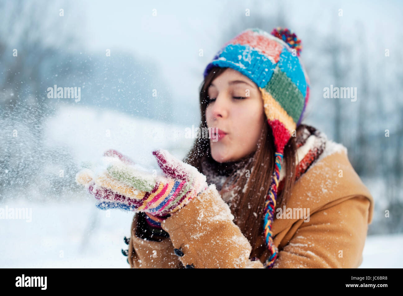 Young woman blowing snow to away Stock Photo - Alamy