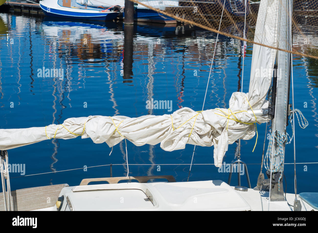 rolled sail on a small sailboat in a harbor Stock Photo - Alamy