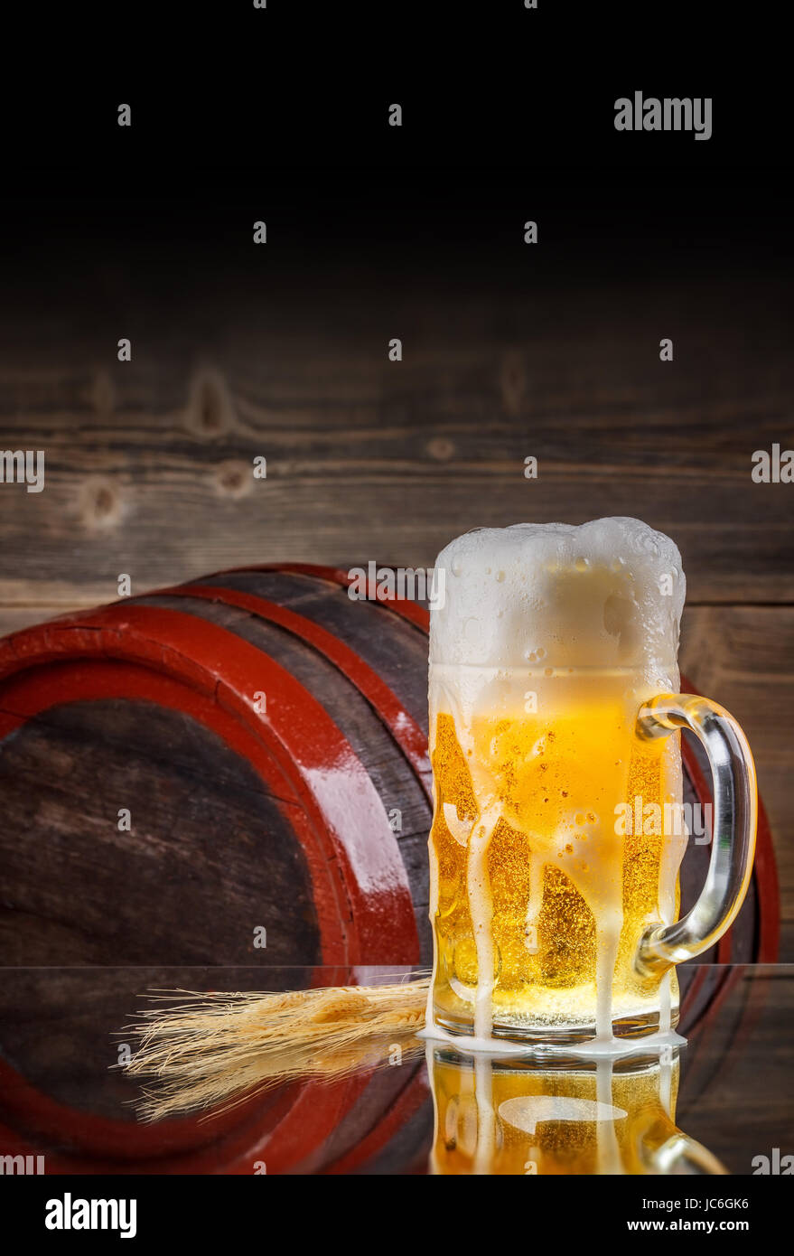 Glass of beer, barrel in background Stock Photo - Alamy