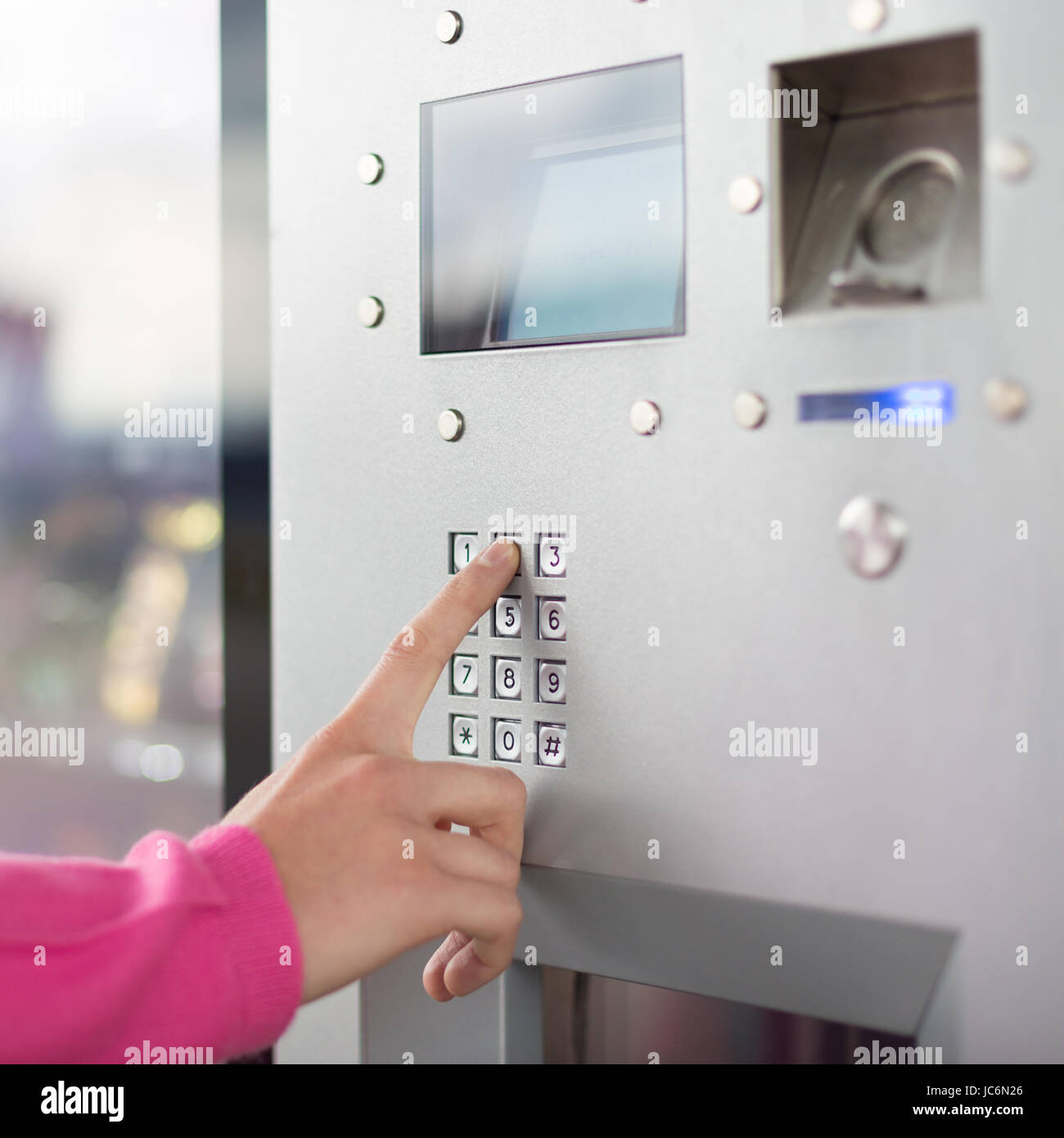 Women's hand using a dial pad on a machine. The fore finger is placed ...