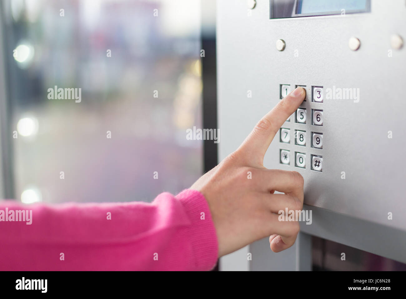 Women's hand using a dial pad on a machine. The fore finger is placed ...